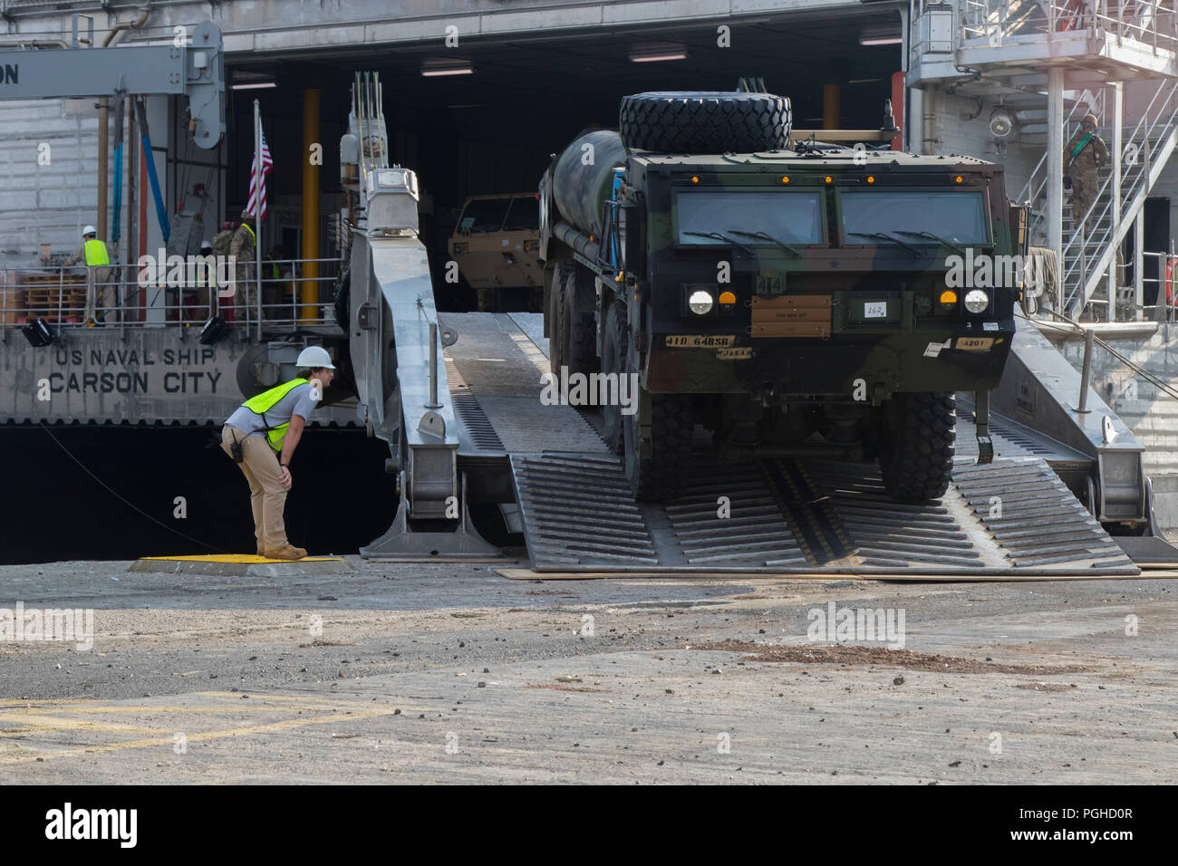 A U.S. Army M978 HEMTT fueler unloads off U.S. Naval Ship Carson City ...