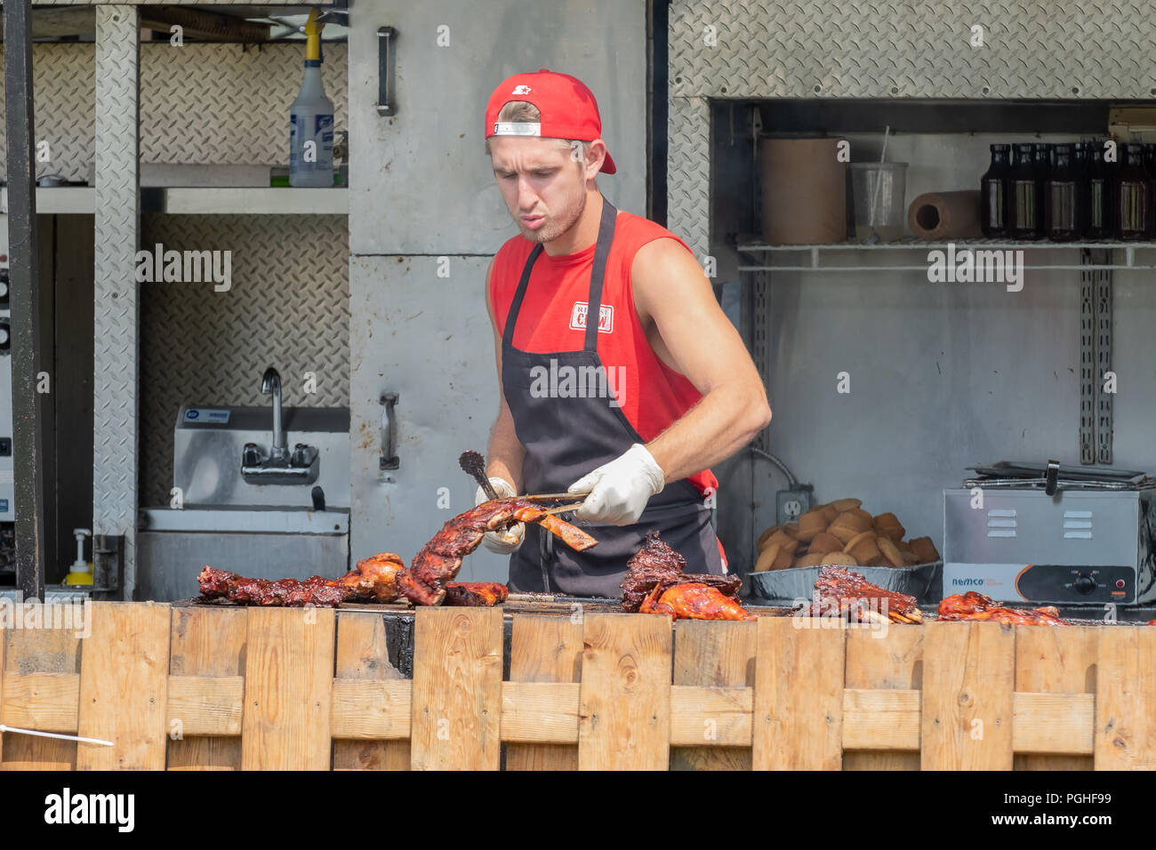 Young BBQ pit master prepares ribs and chicken at the annual Ribfest in ...