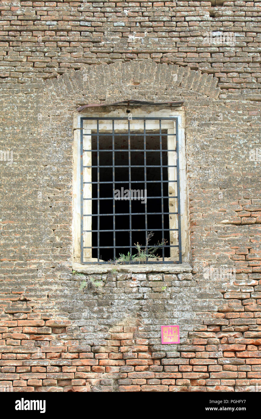 Prison cell wall with a window with bars Stock Photo - Alamy