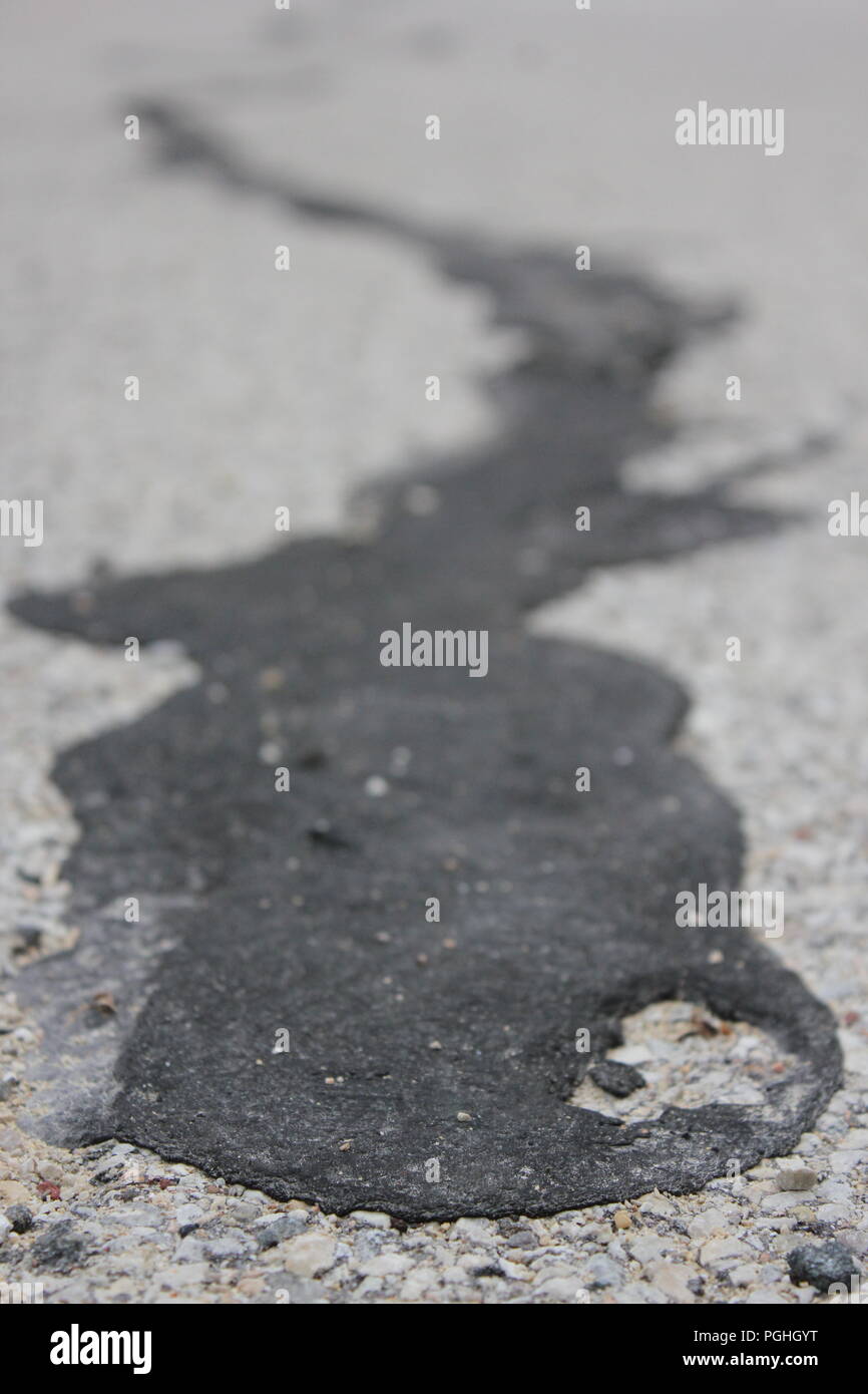 A pavement surface fixed by the application of a black tar Stock Photo ...