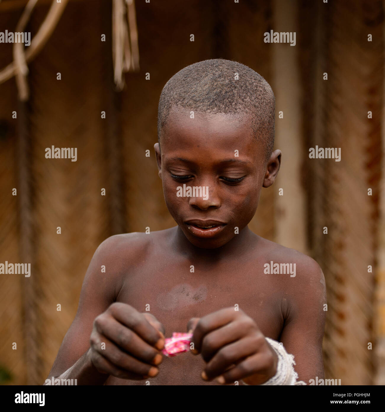 LOME, TOGO - Jan 9, 2017: Unidentified Togolese young boy opens a candy ...