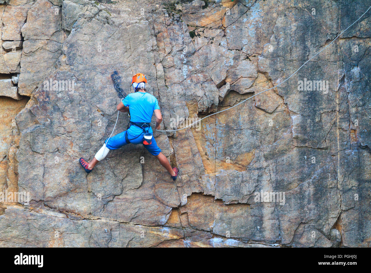 Climber fixes insurance on a steep cliff Stock Photo - Alamy