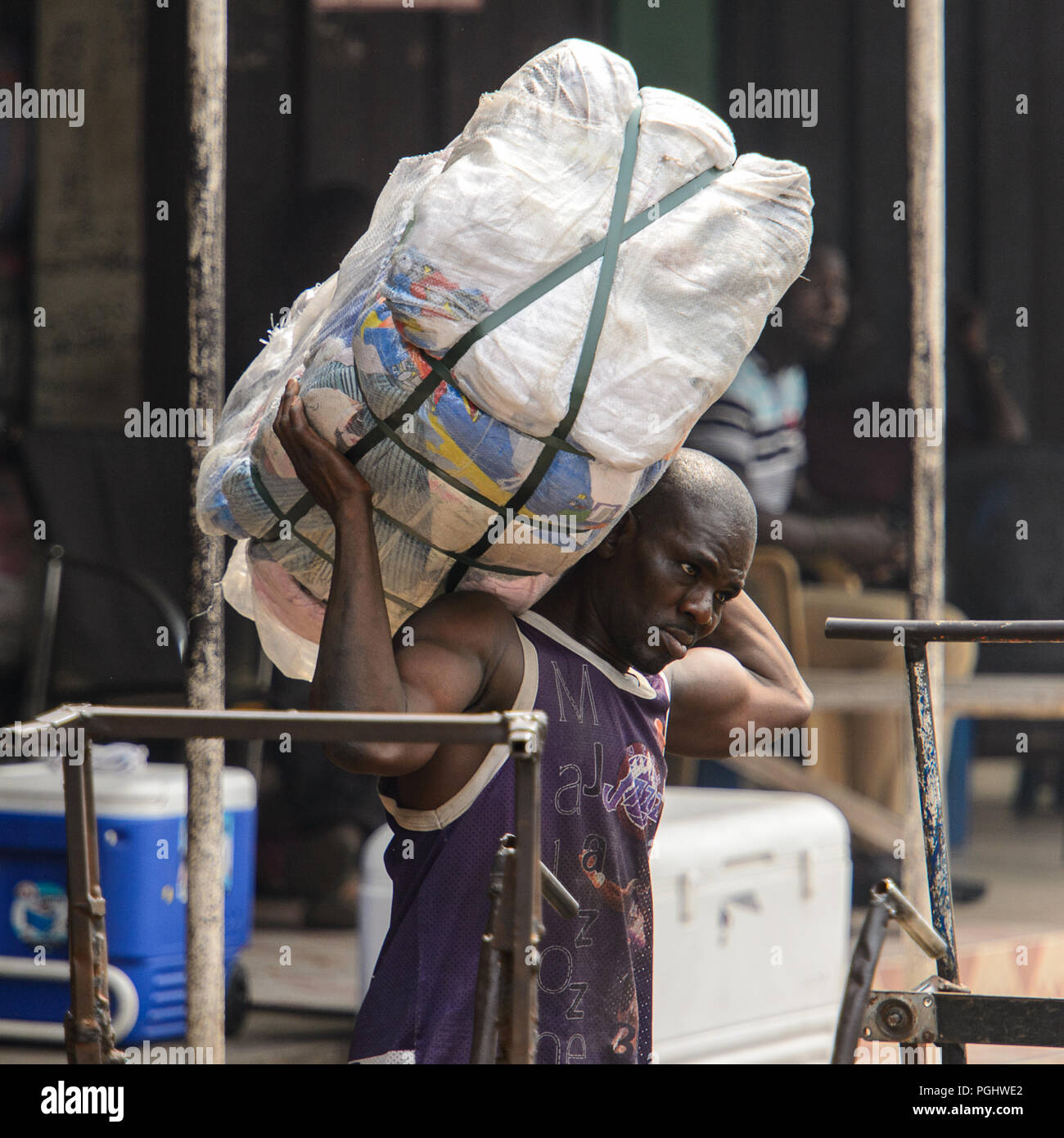 KUMASI, GHANA - Jan 16, 2017: Unidentified Ghanaian man carries a heavy ...