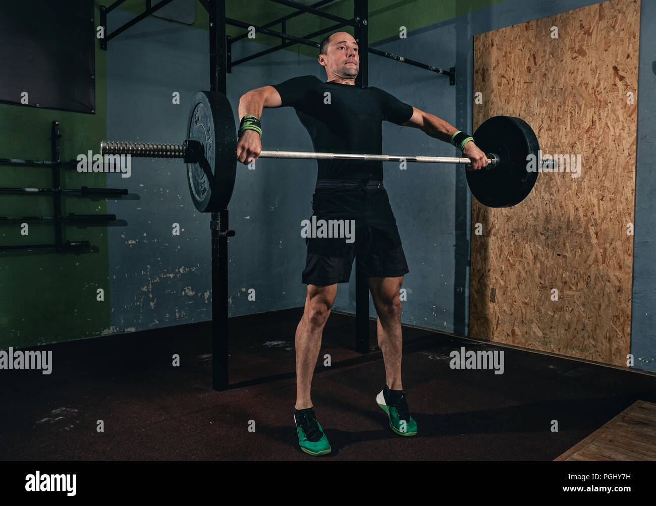 Strong crossfit athlete in the middle a heavy snatch lift in a cross ...