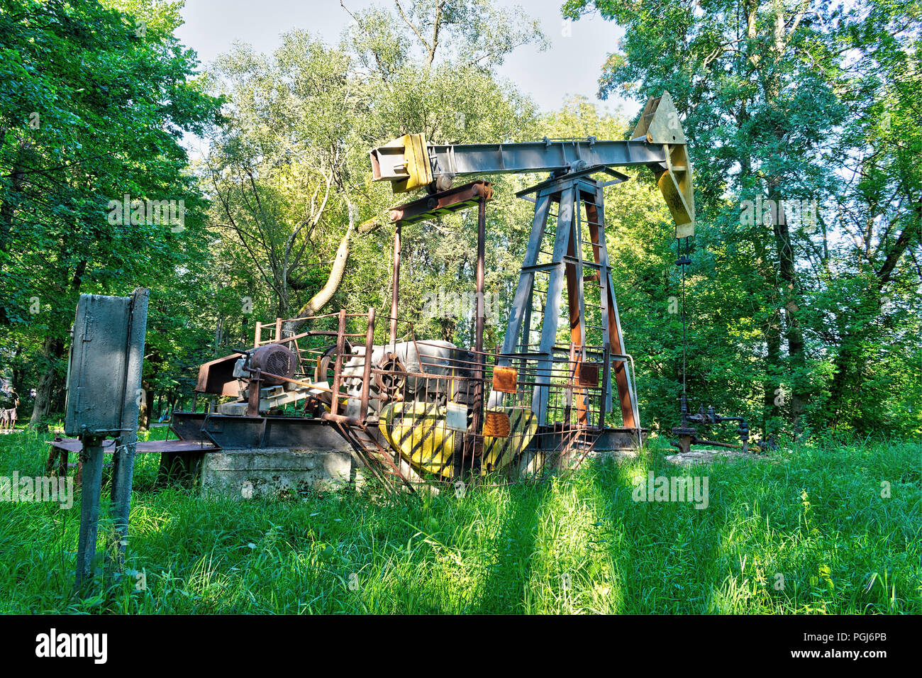 Oil pump at work on the oil well in the forest Stock Photo - Alamy