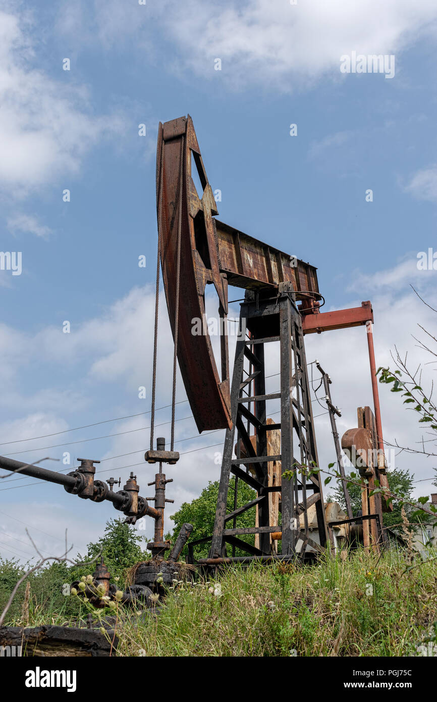 Oil rig is pumping the oil with beautiful landscape on the background ...