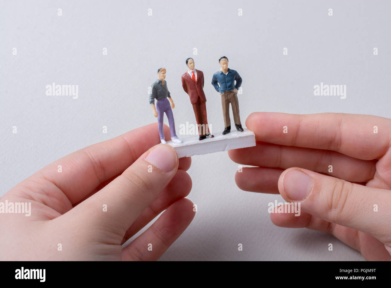 Tiny figurines of men miniature model in hand Stock Photo - Alamy