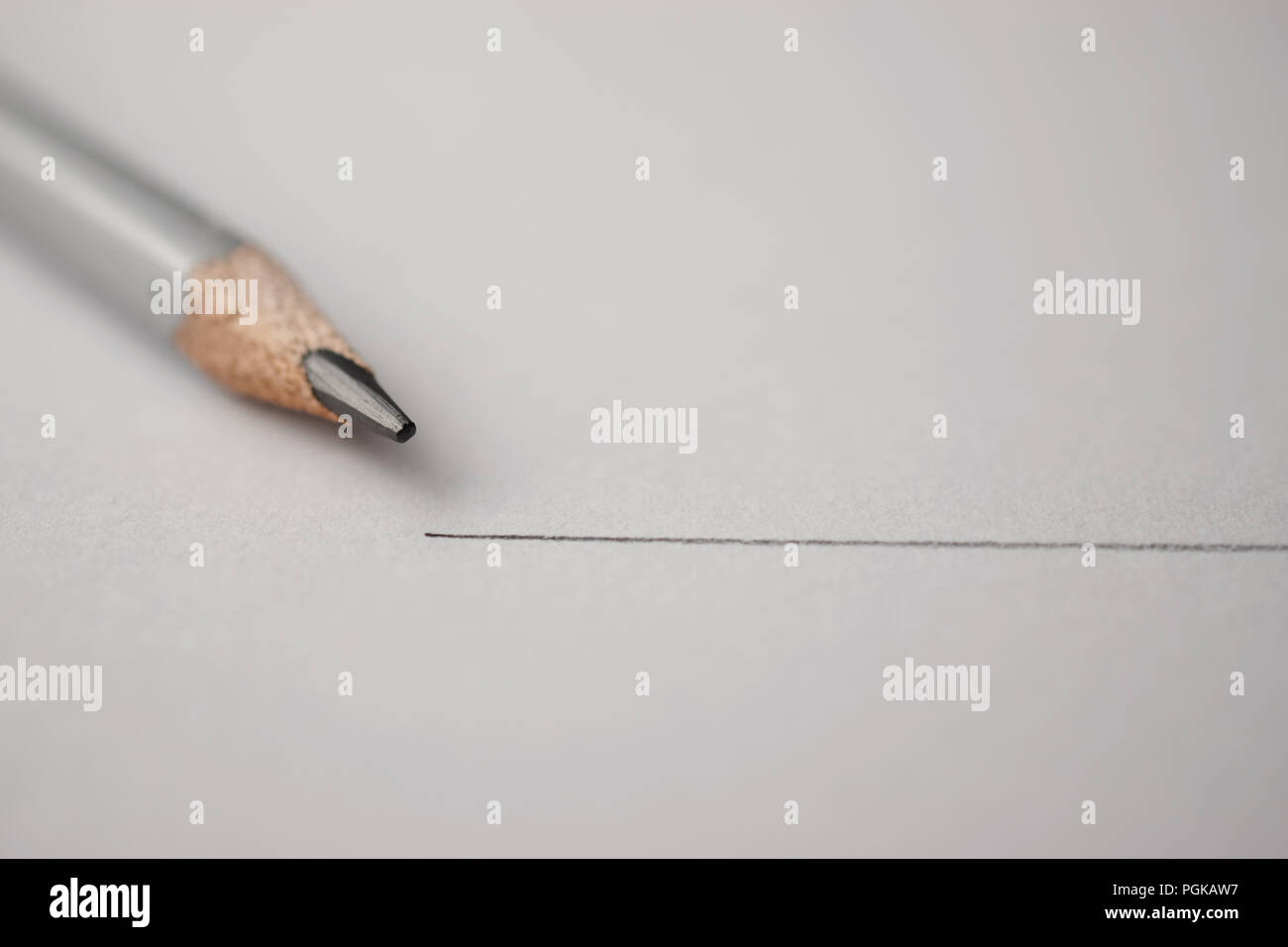 Macro shot of black pencil graphite with drawing line on textured white ...