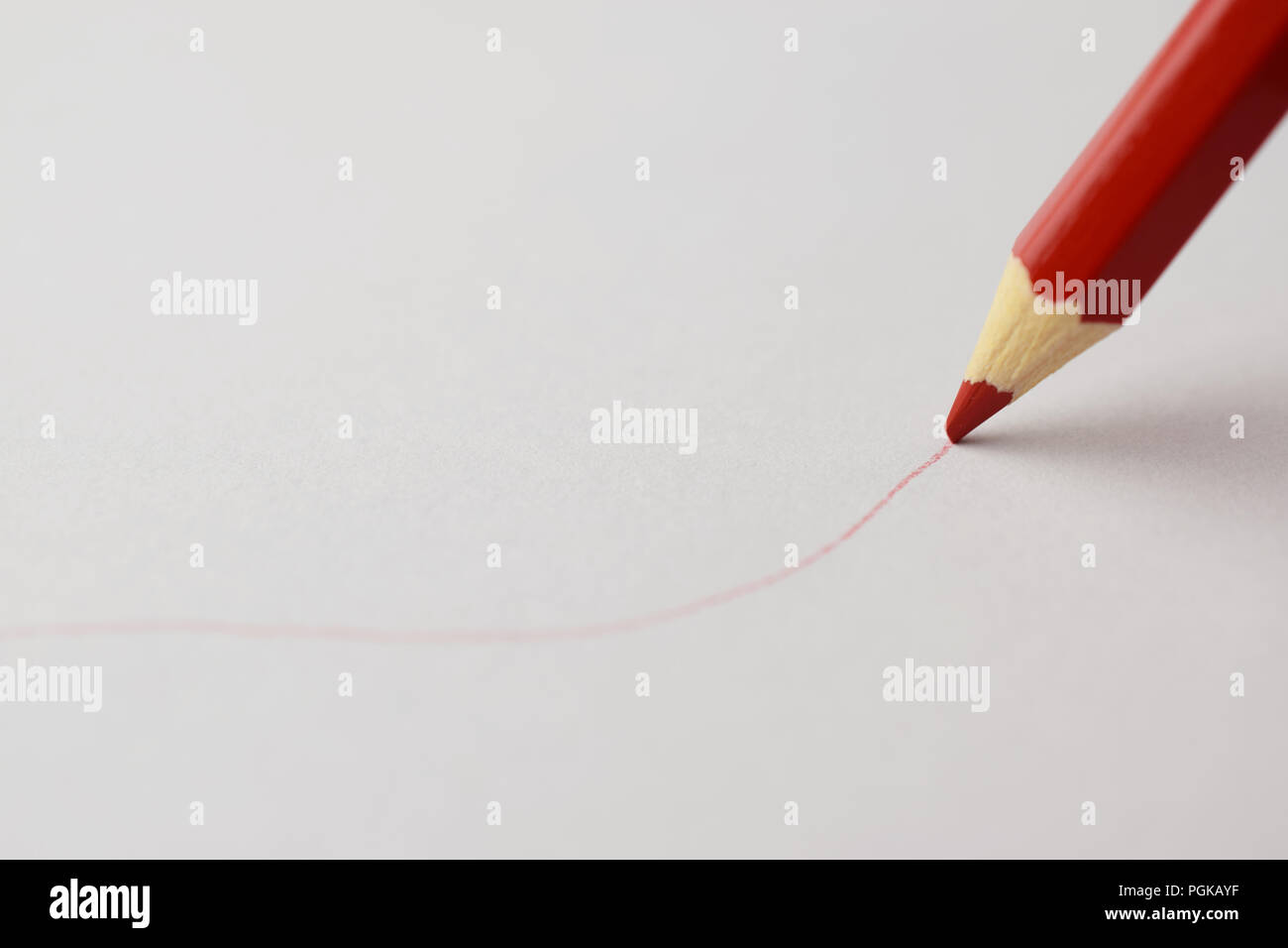 Red pencil drawing a red line on a white paper Stock Photo - Alamy