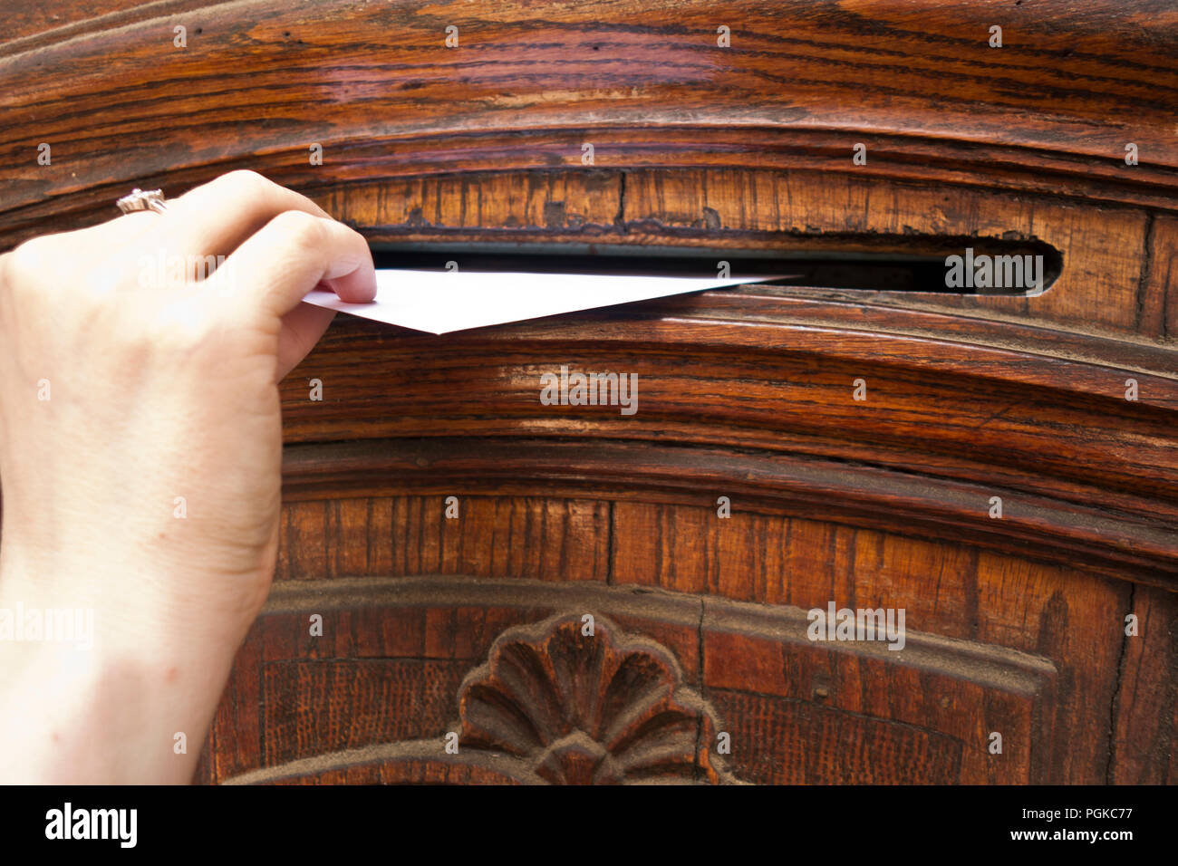 woman hand putting an envelope into a mail slot Stock Photo - Alamy