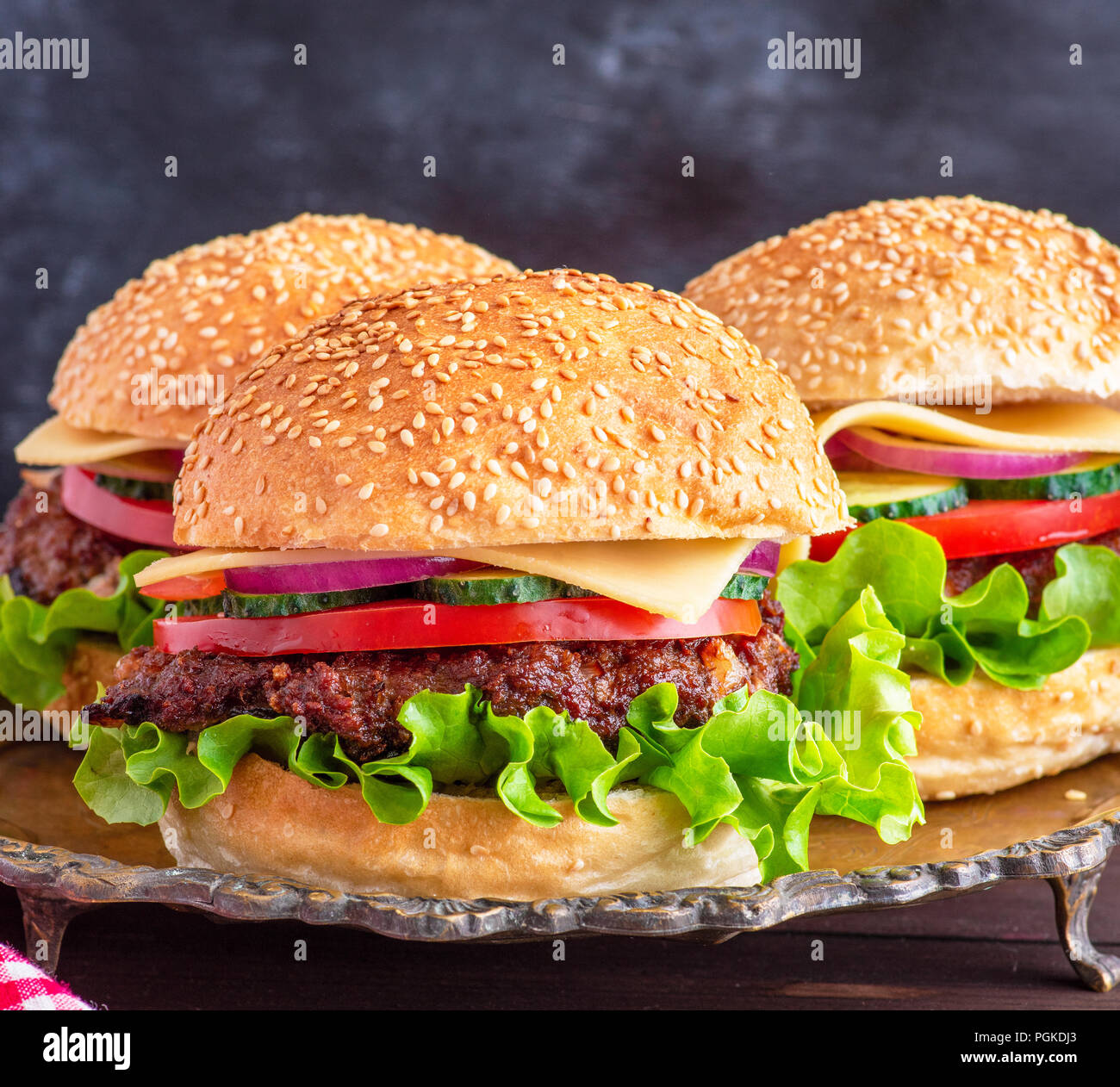 burger with fried cutlet, cheese and vegetables in a round wheat flour ...
