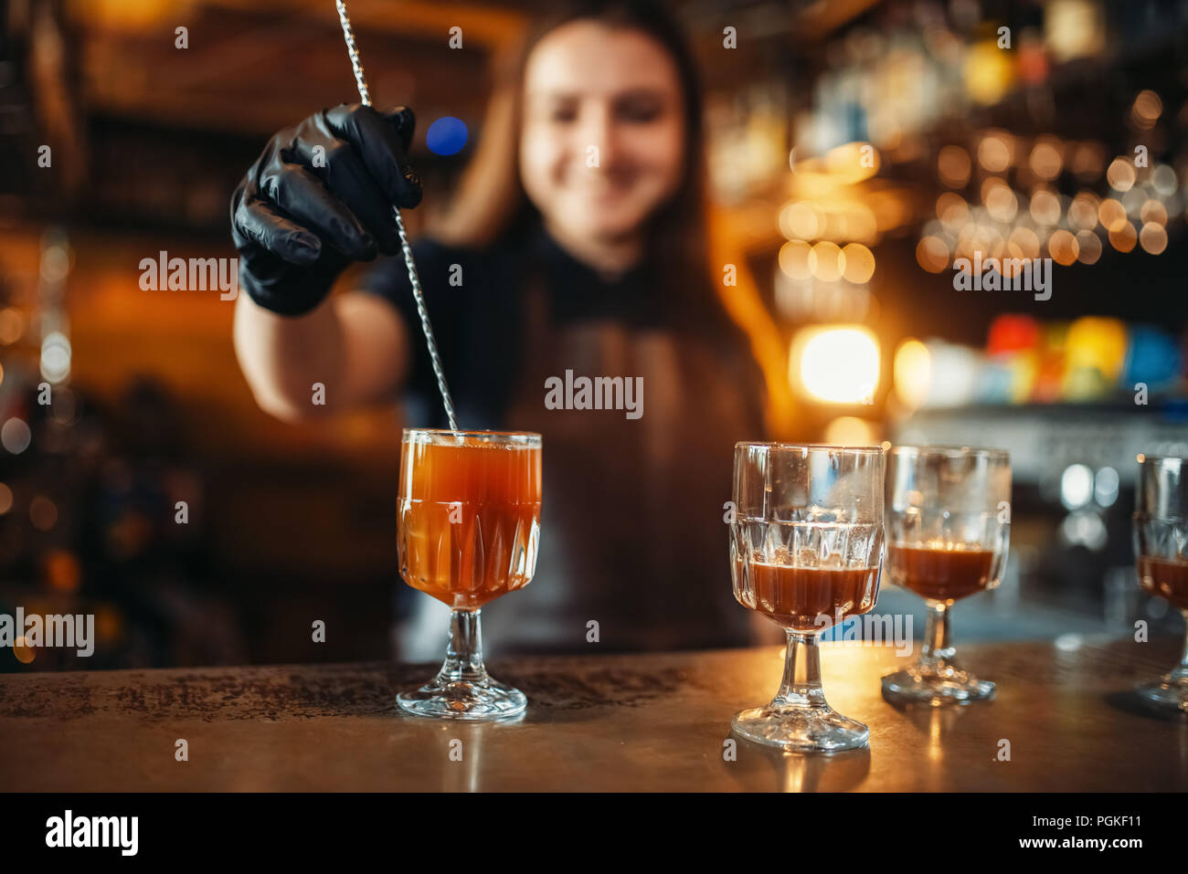 Female bartender making coctail at the bar counter. Alcohol drink ...