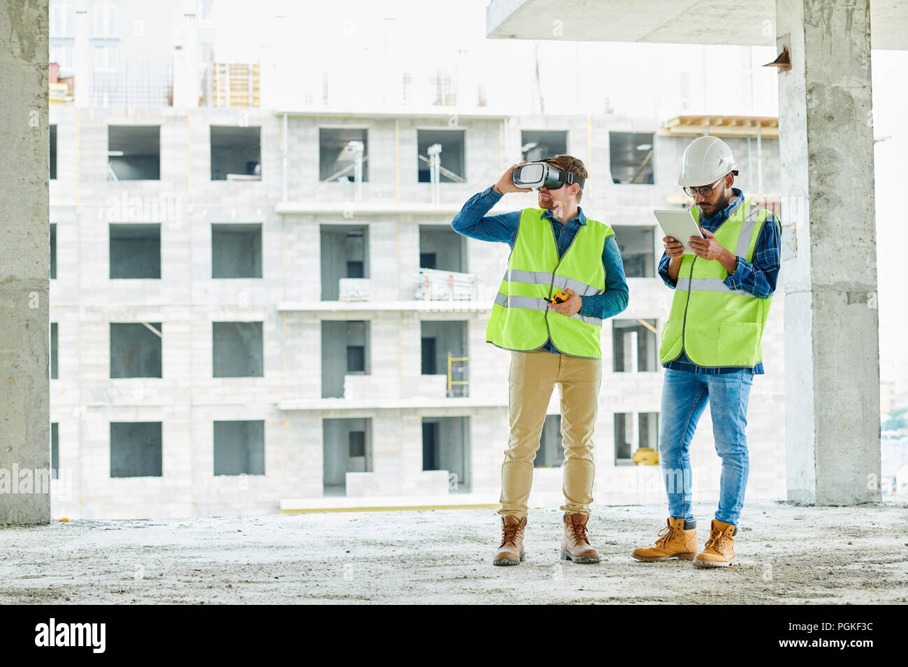 Full length portrait of two contemporary crew workers using VR to ...