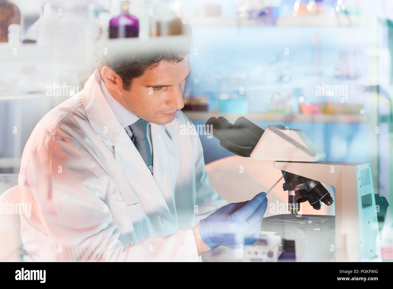 Life science male researcher microscoping in scientific genetic ...