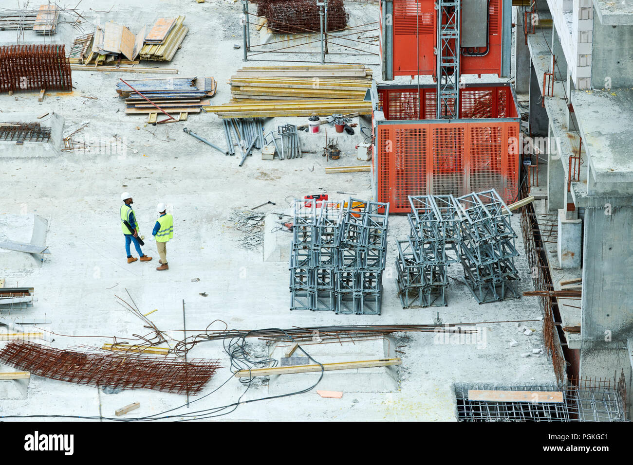Wide angle shot of construction site with two workers discussing ...