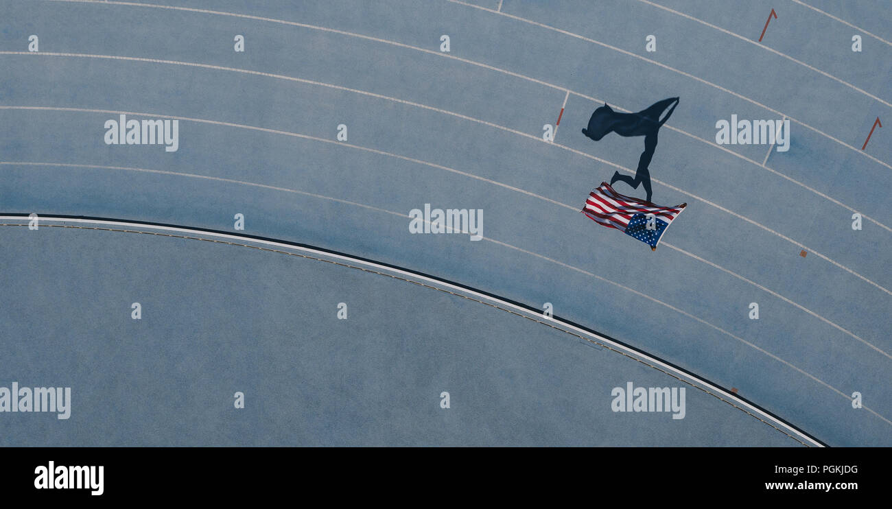 Aerial view of an athlete running on athletic track holding the ...