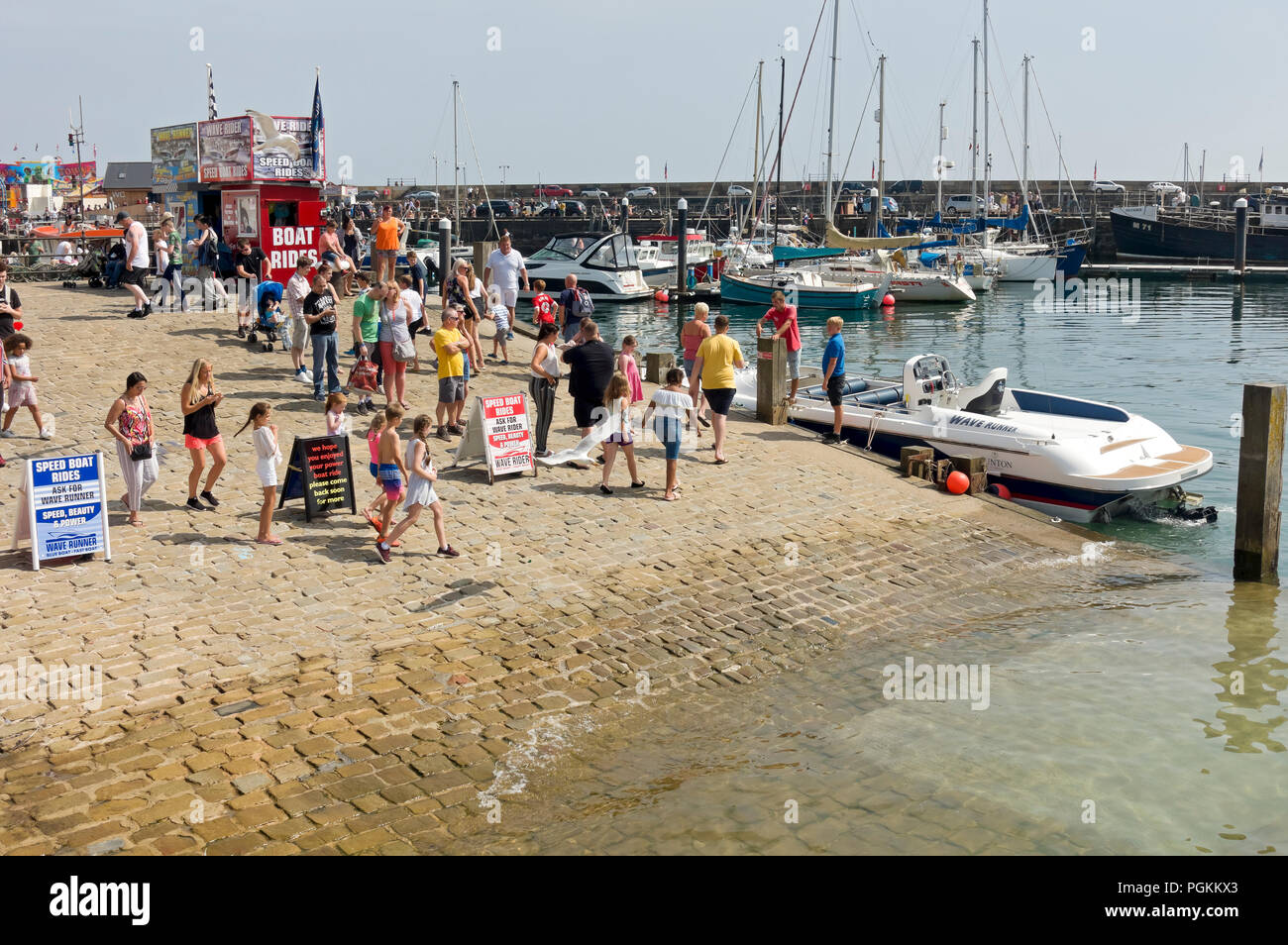 People tourists visitors waiting queuing for speed boat rides in summer ...