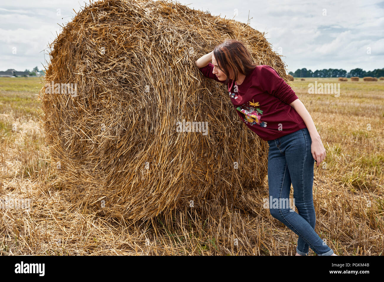 young girl having fun in the field, stands at haystack Stock Photo - Alamy