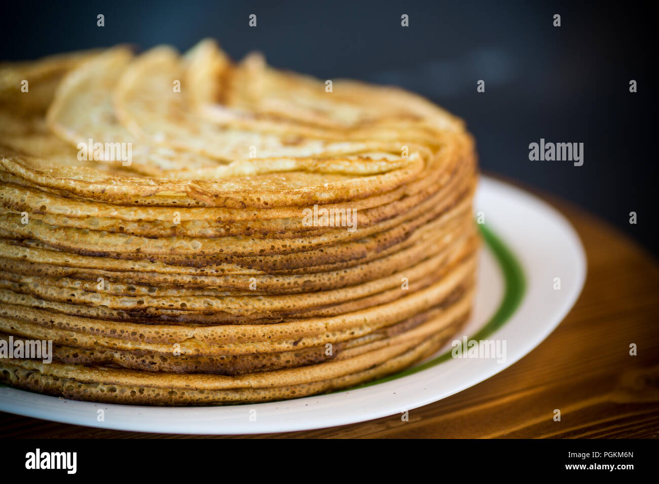 big high stack of thin pancakes in a plate on a black background Stock ...