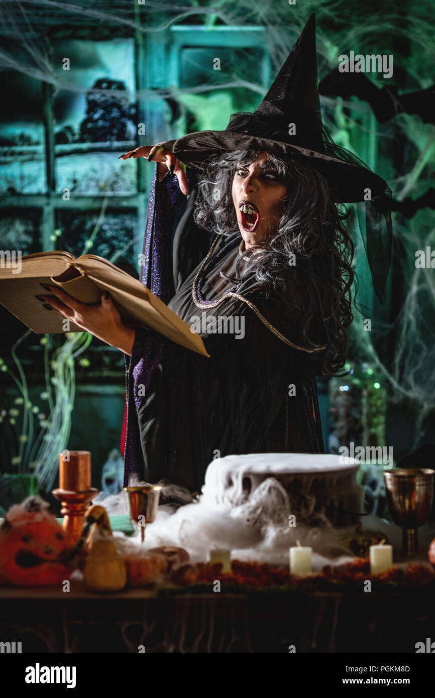 Witch with awfully face in creepy surroundings and smoky green ...