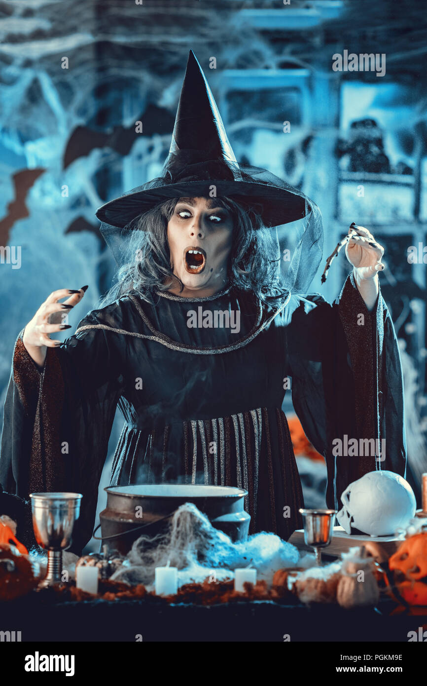 Witch with awfully face in creepy surroundings full of cobweb sends ...