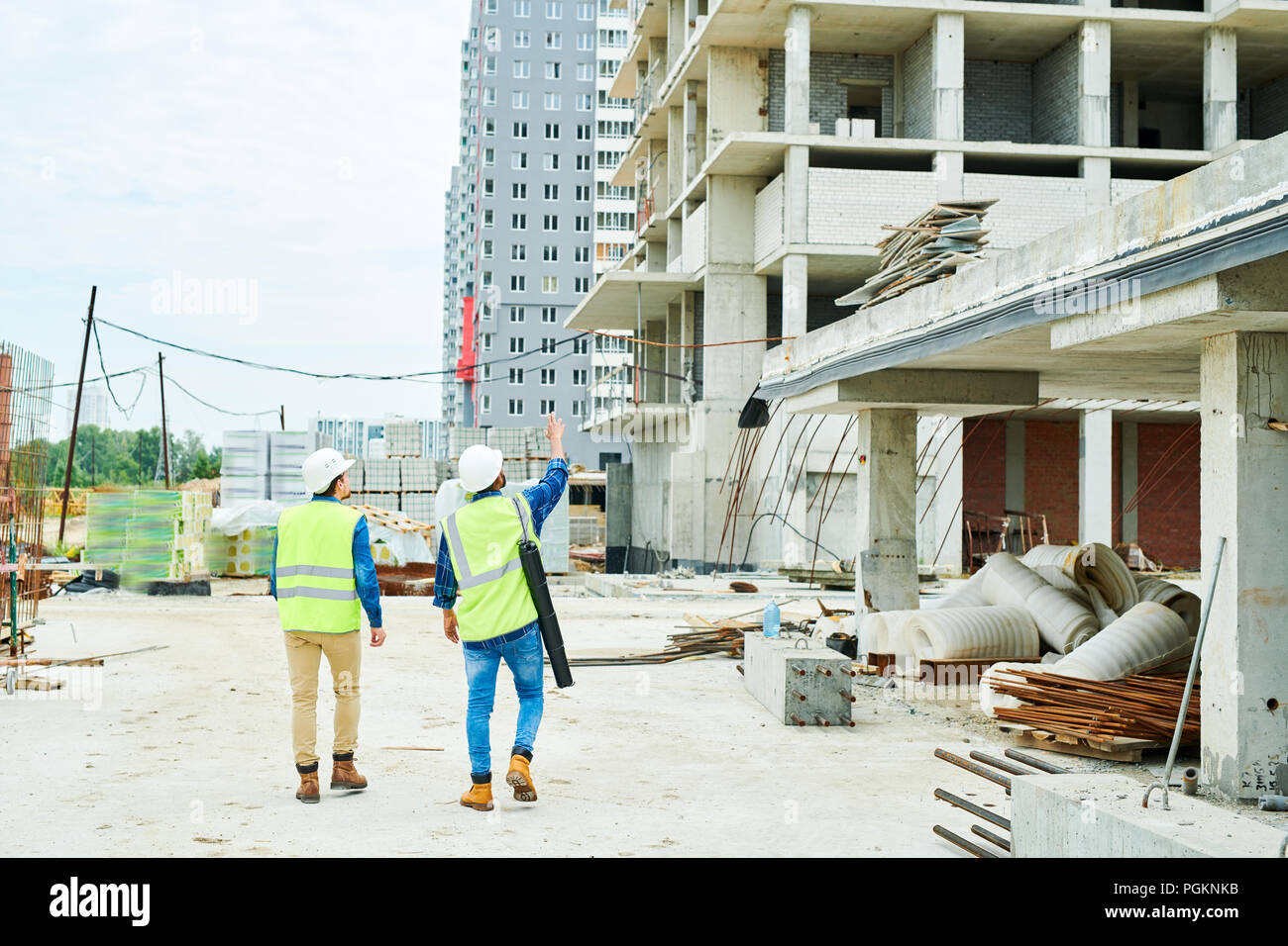 Back view full length portrait of two construction workers wearing ...
