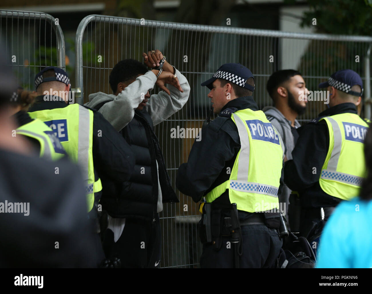 Police officers handcuff a man at the Notting Hill Carnival in west ...