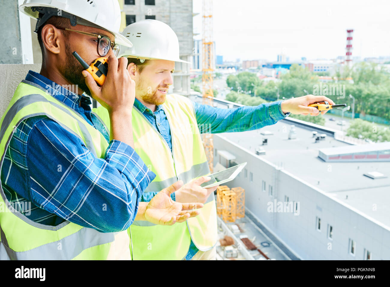 Side view portrait of two construction workers wearing hardhats and ...