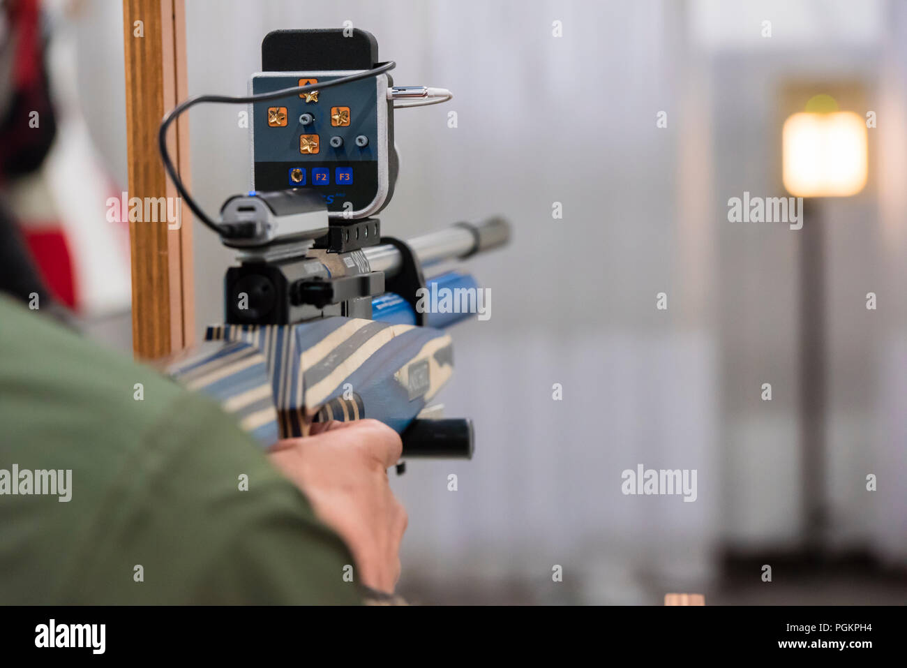 A blind man is aiming a specially equipped rifle at the target on a ...