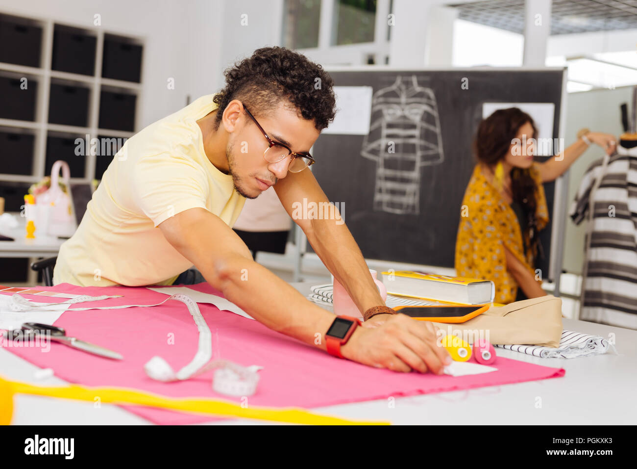 Concentrated tailor frowning while working in the atelier Stock Photo ...