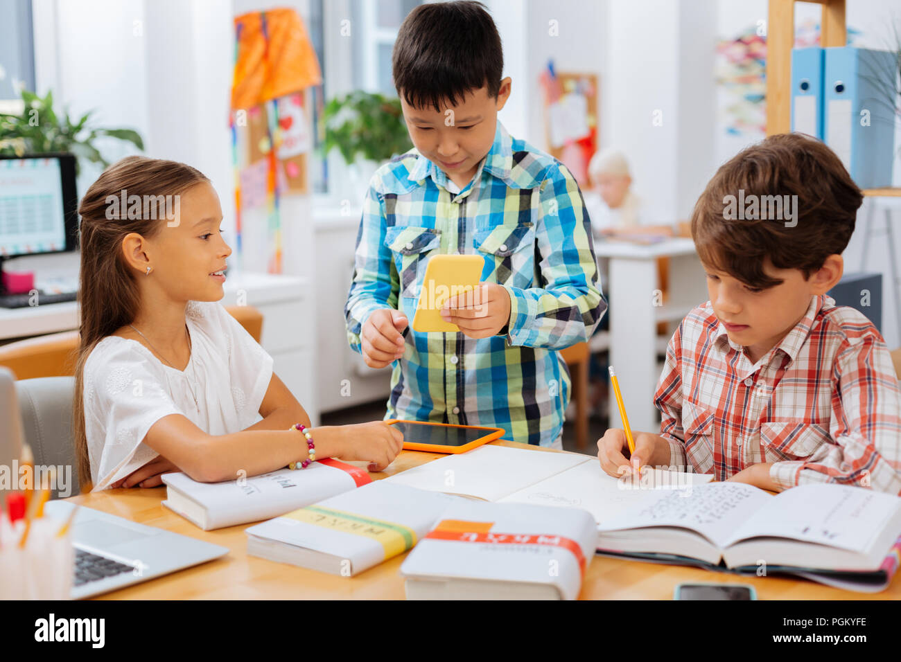 Cheerful children sharing their notes with each other Stock Photo - Alamy