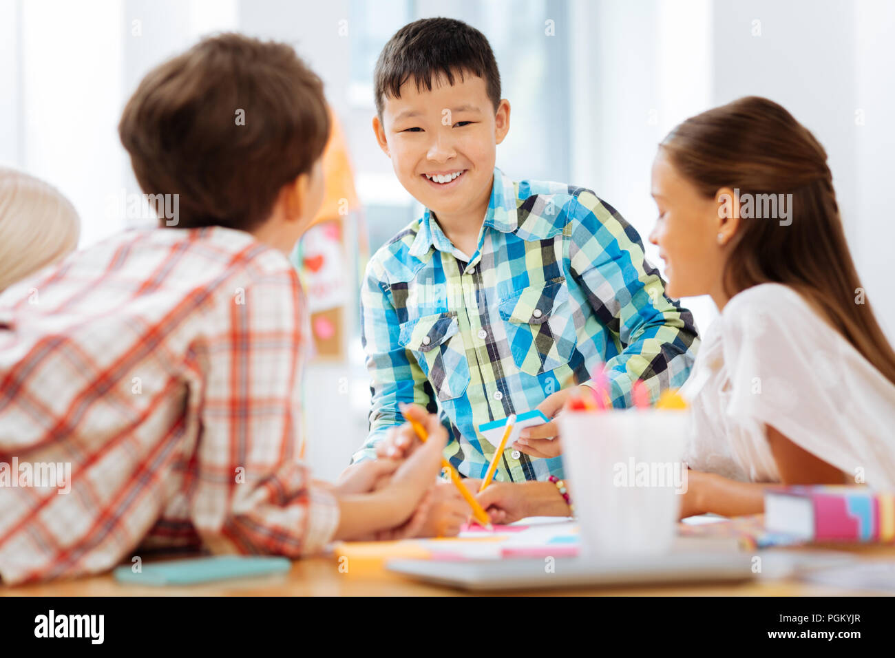 Cheerful boy drawing a picture with classmates Stock Photo - Alamy