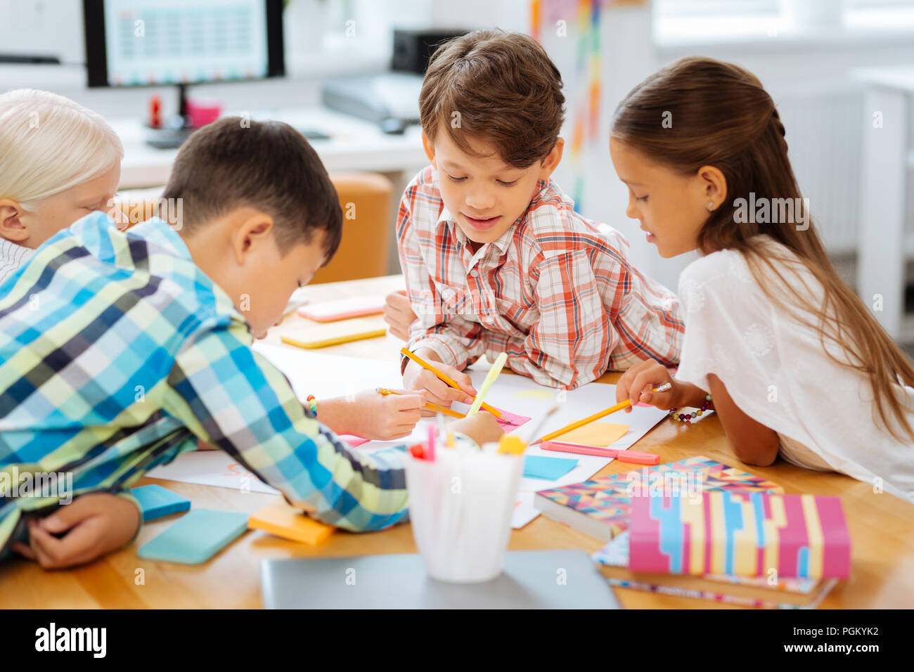 Classmates drawing pictures together in a classroom Stock Photo - Alamy