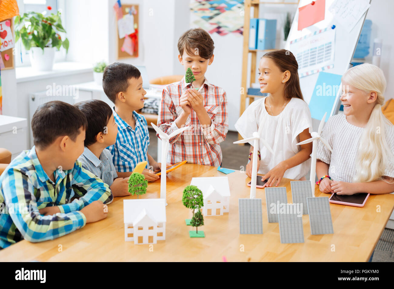 Creative kids making paper figures together in a classroom Stock Photo ...
