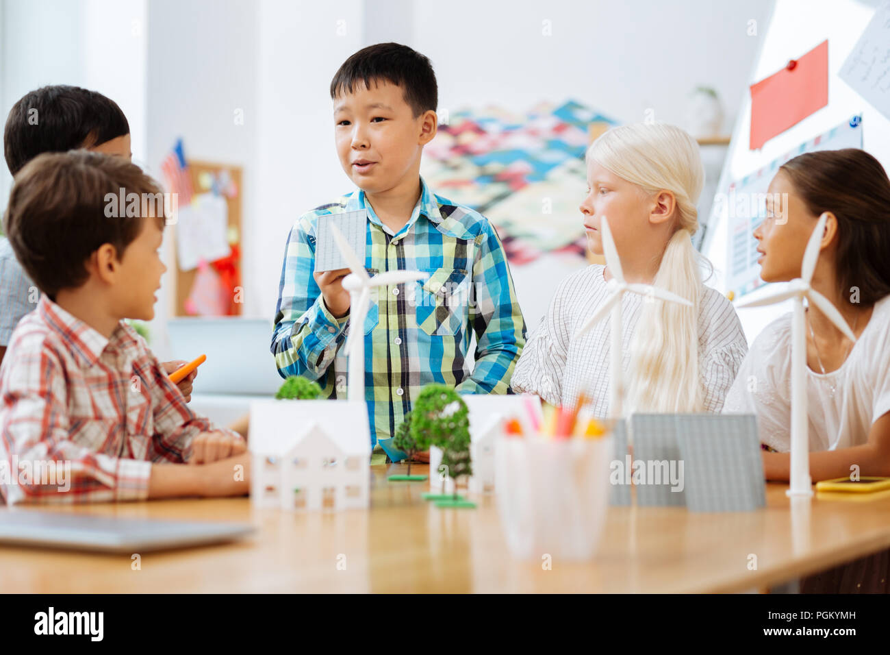 Talkative boy speaking with classmates in a classroom Stock Photo - Alamy