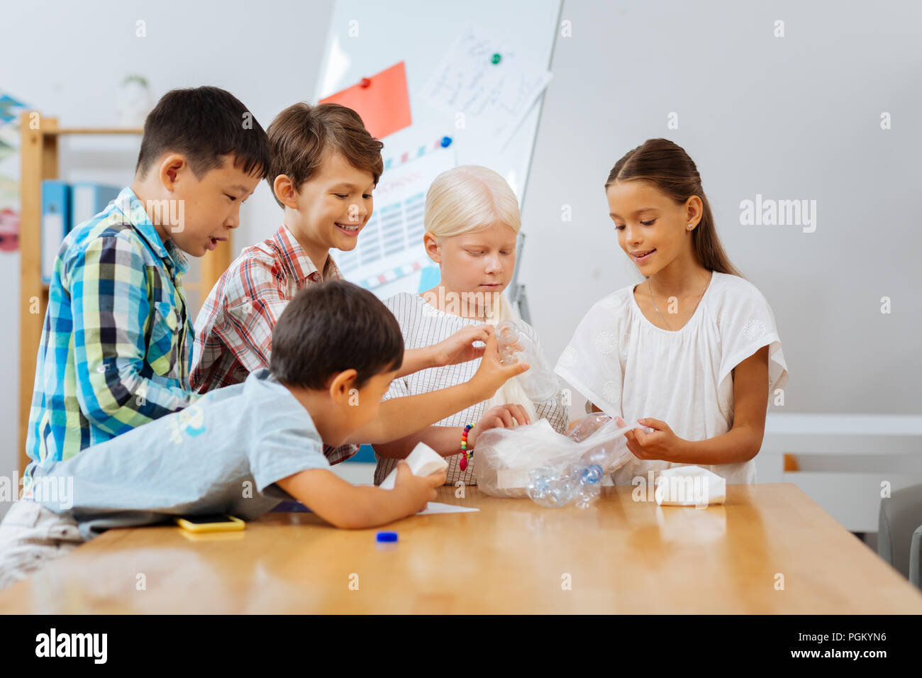 Smart kids gathering plastic bottles at school Stock Photo - Alamy