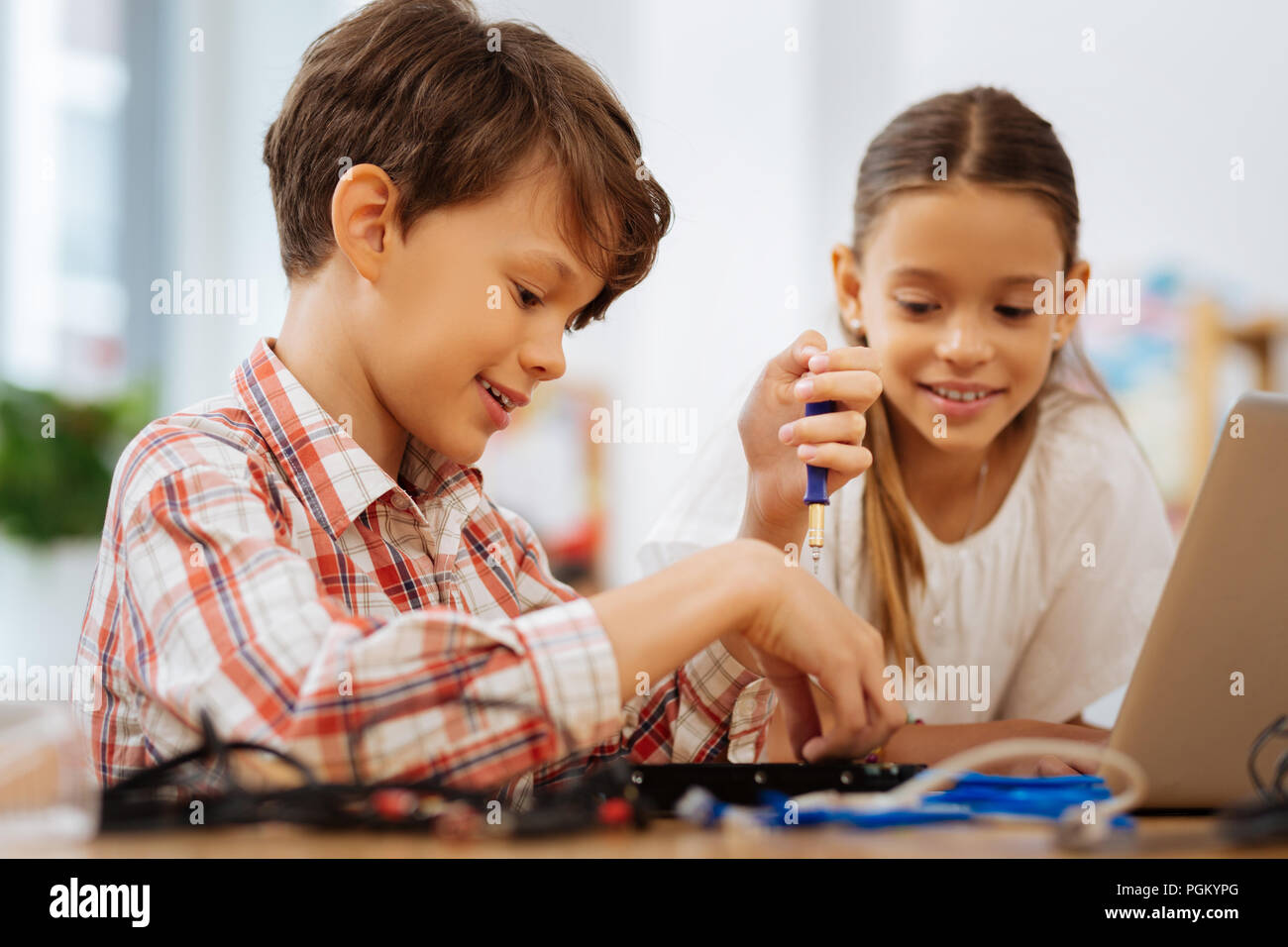 Schoolchildren dealing with new devices at school Stock Photo - Alamy