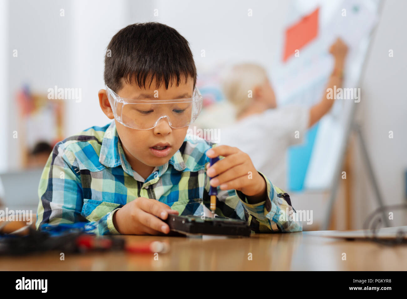 Interested boy studying a new device at school Stock Photo - Alamy