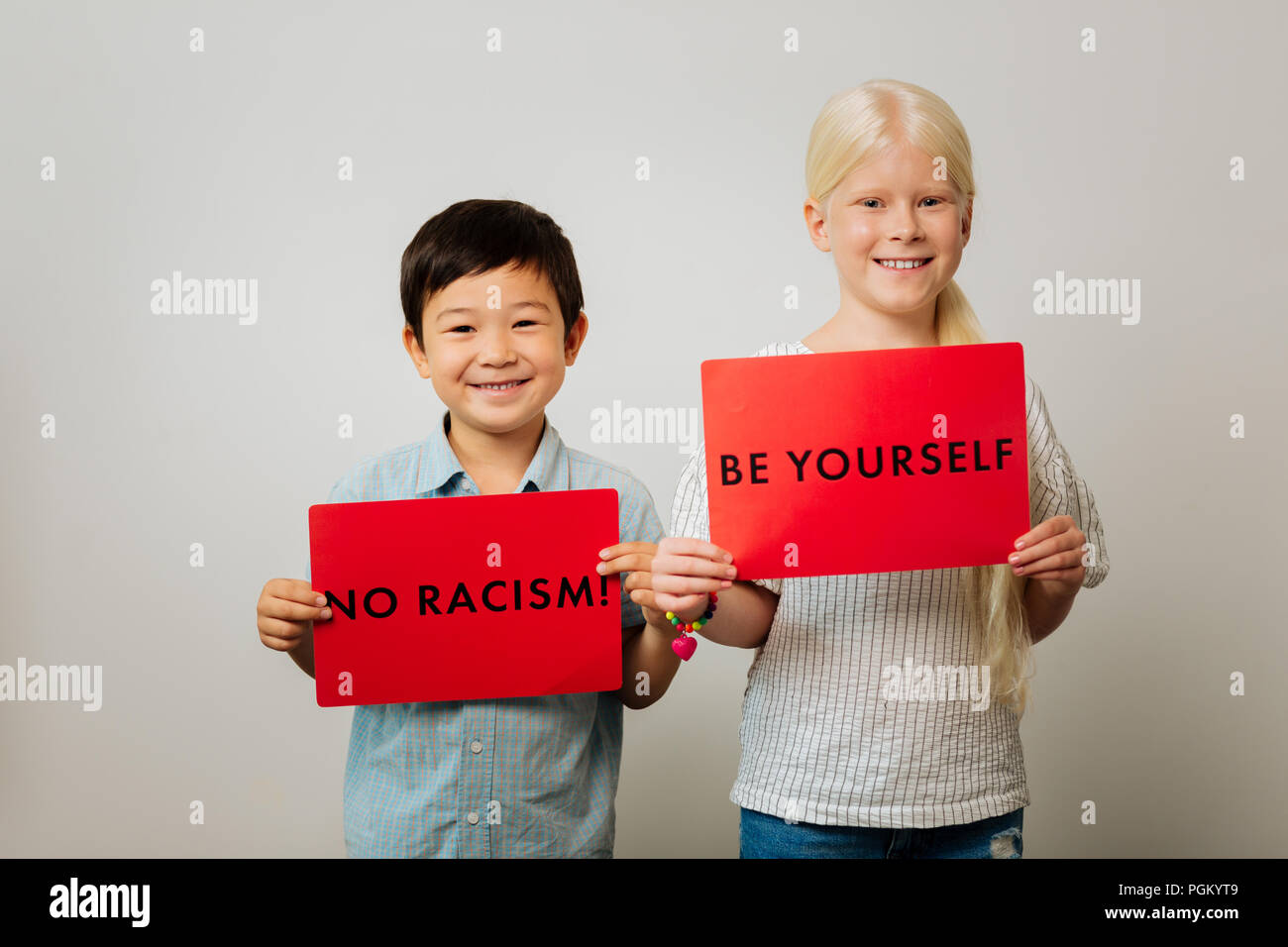 Smart children holding tables against racism in their hands Stock Photo ...