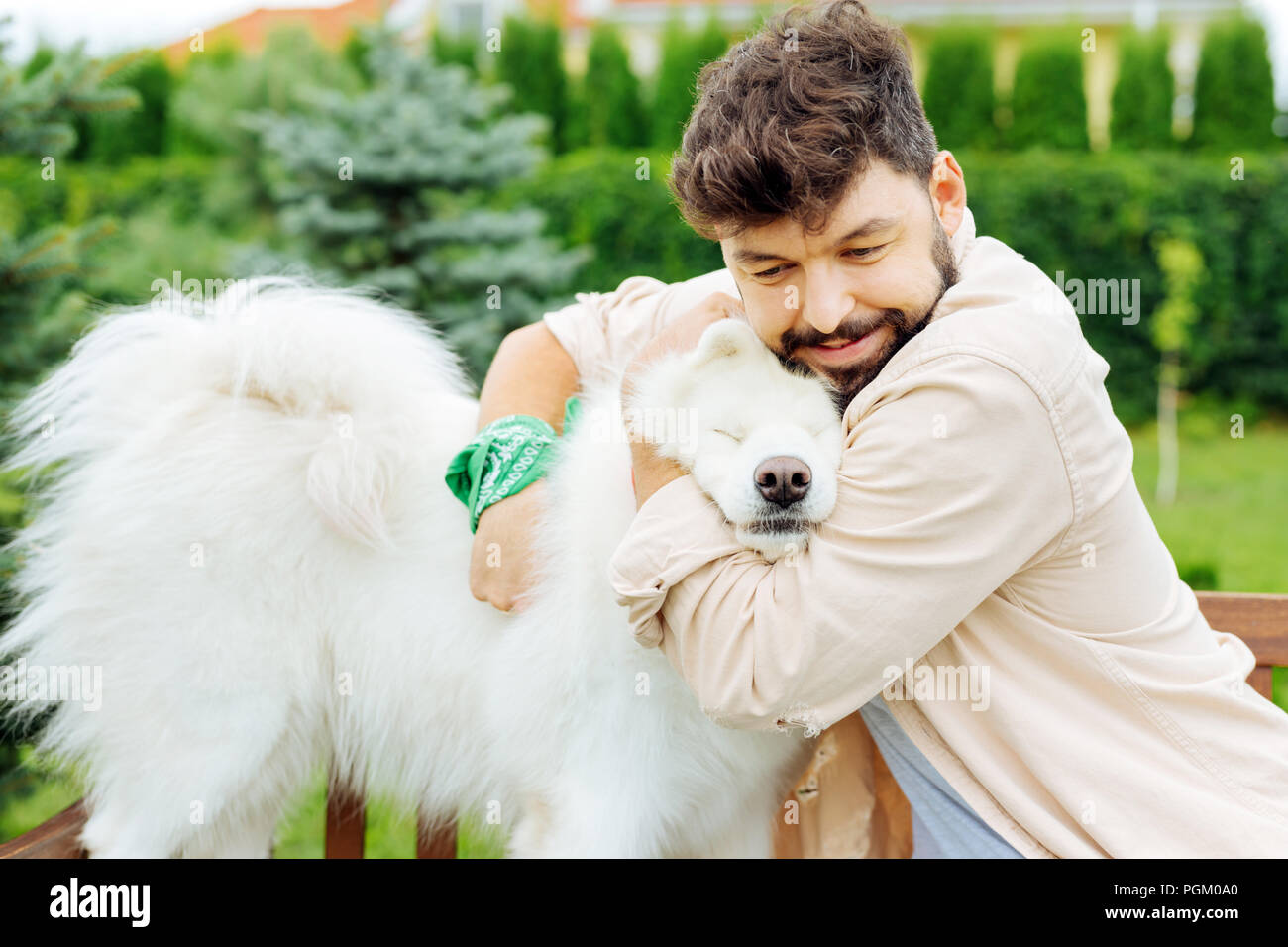Loving owner of cute white husky hugging his dog Stock Photo - Alamy