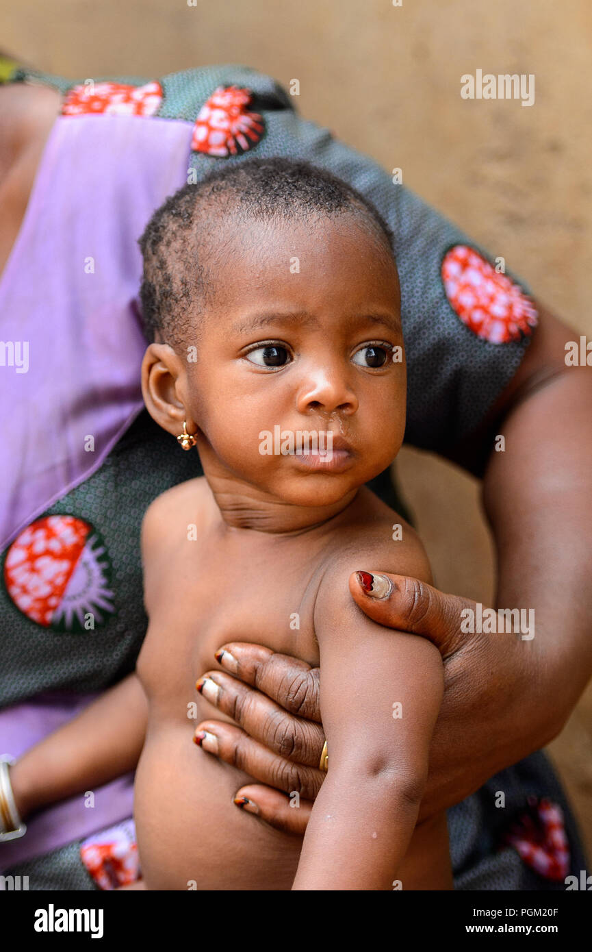 PIRA, BENIN - JAN 12, 2017: Unidentified Beninese baby girl is carried ...
