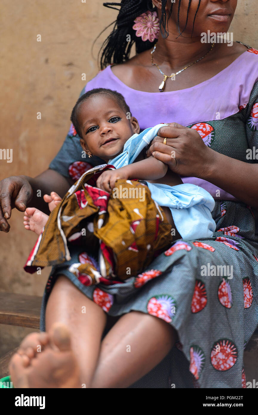 PIRA, BENIN - JAN 12, 2017: Unidentified Beninese baby girl is carried ...