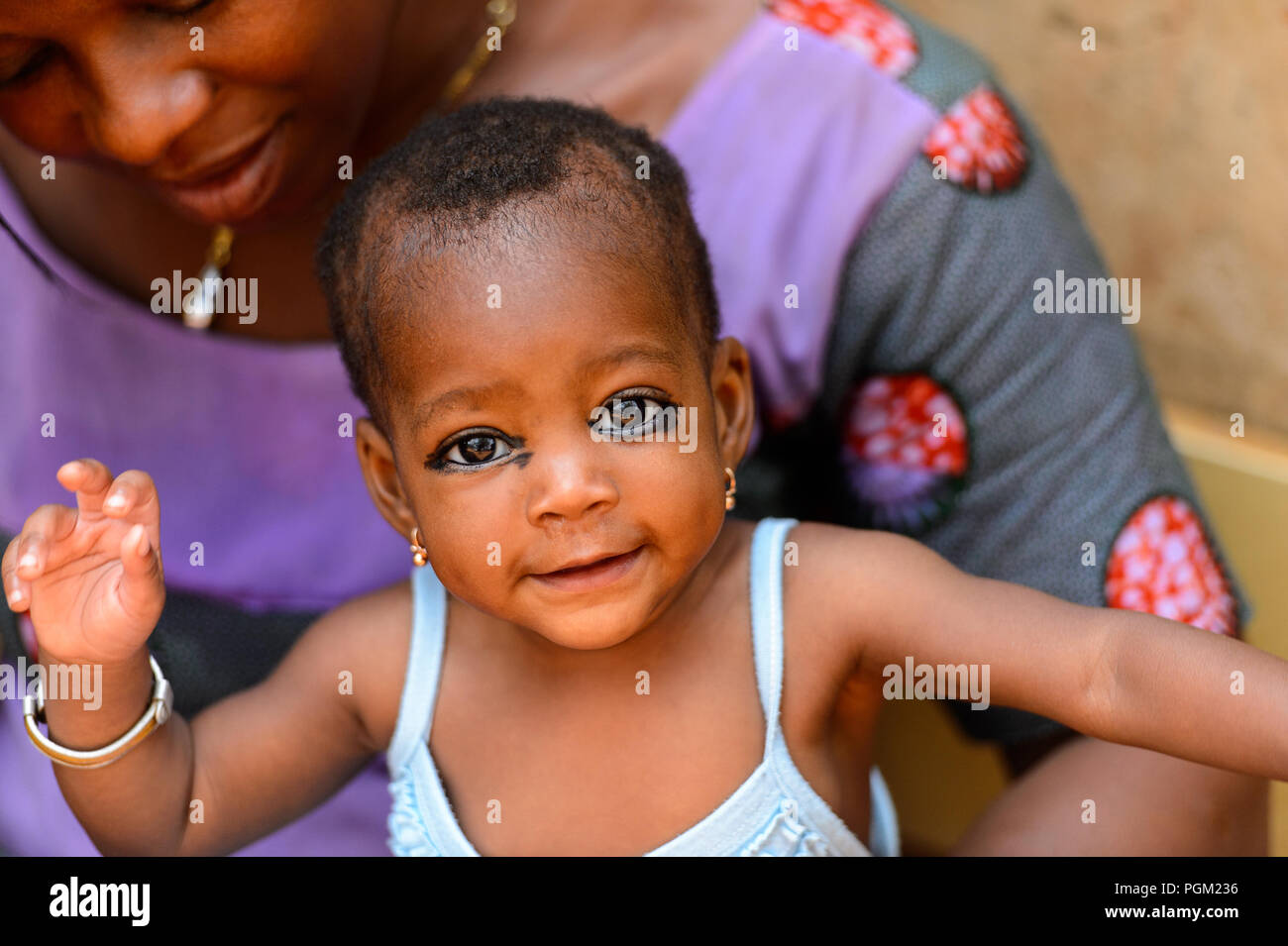 PIRA, BENIN - JAN 12, 2017: Unidentified Beninese baby girl is carried ...