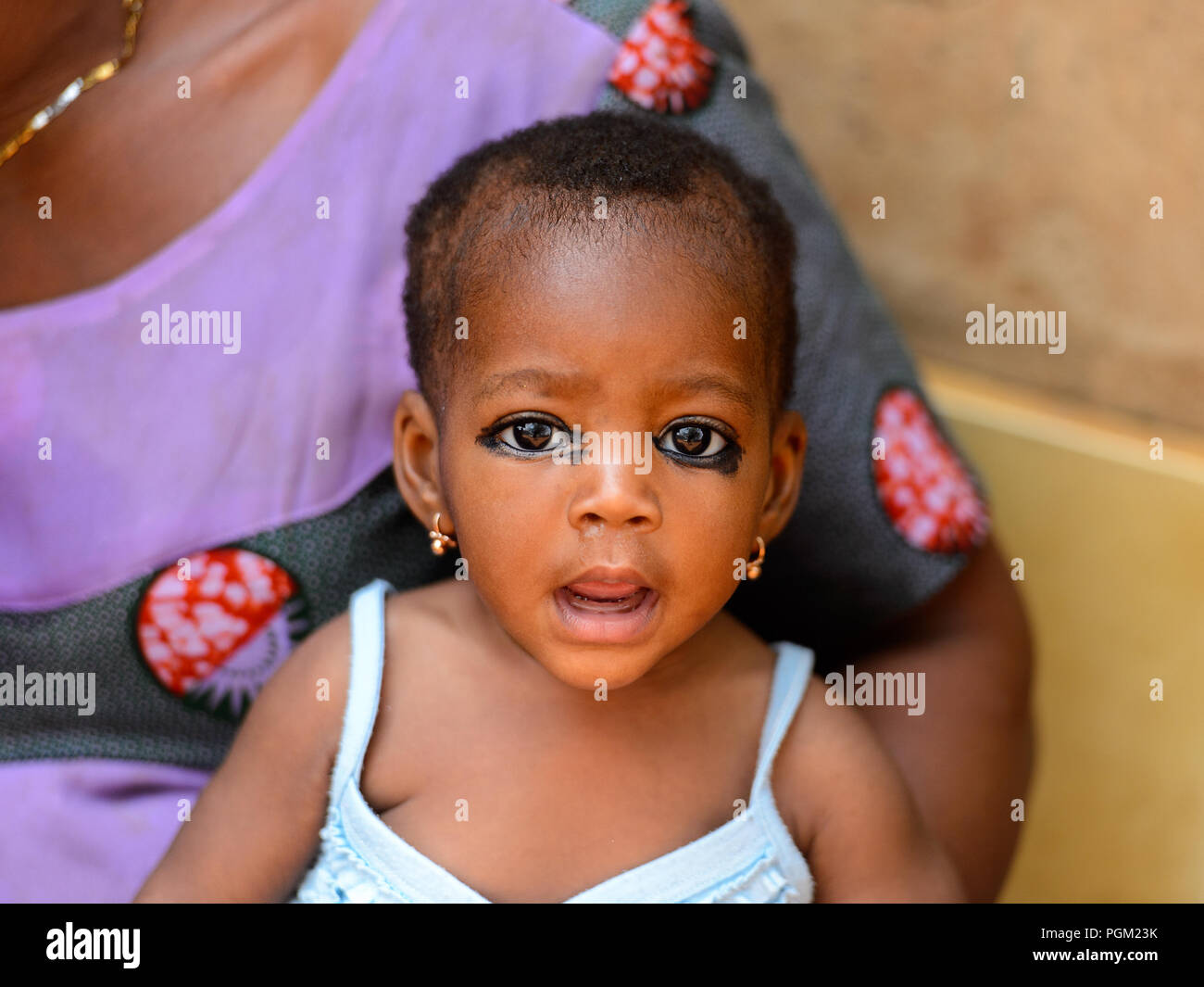 PIRA, BENIN - JAN 12, 2017: Unidentified Beninese baby girl is carried ...