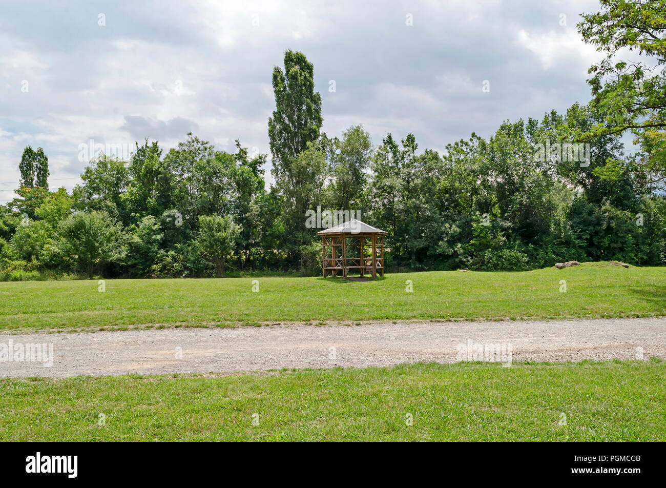 Wooden bench, alcove and table on a meadow in the forest at natural old ...