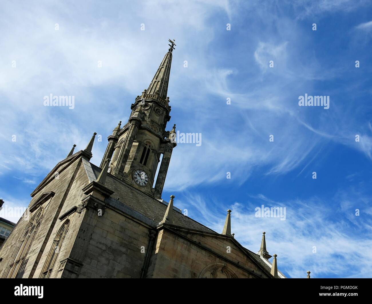 Building with a tower clock against blue skies in Edinburgh, Scotland ...