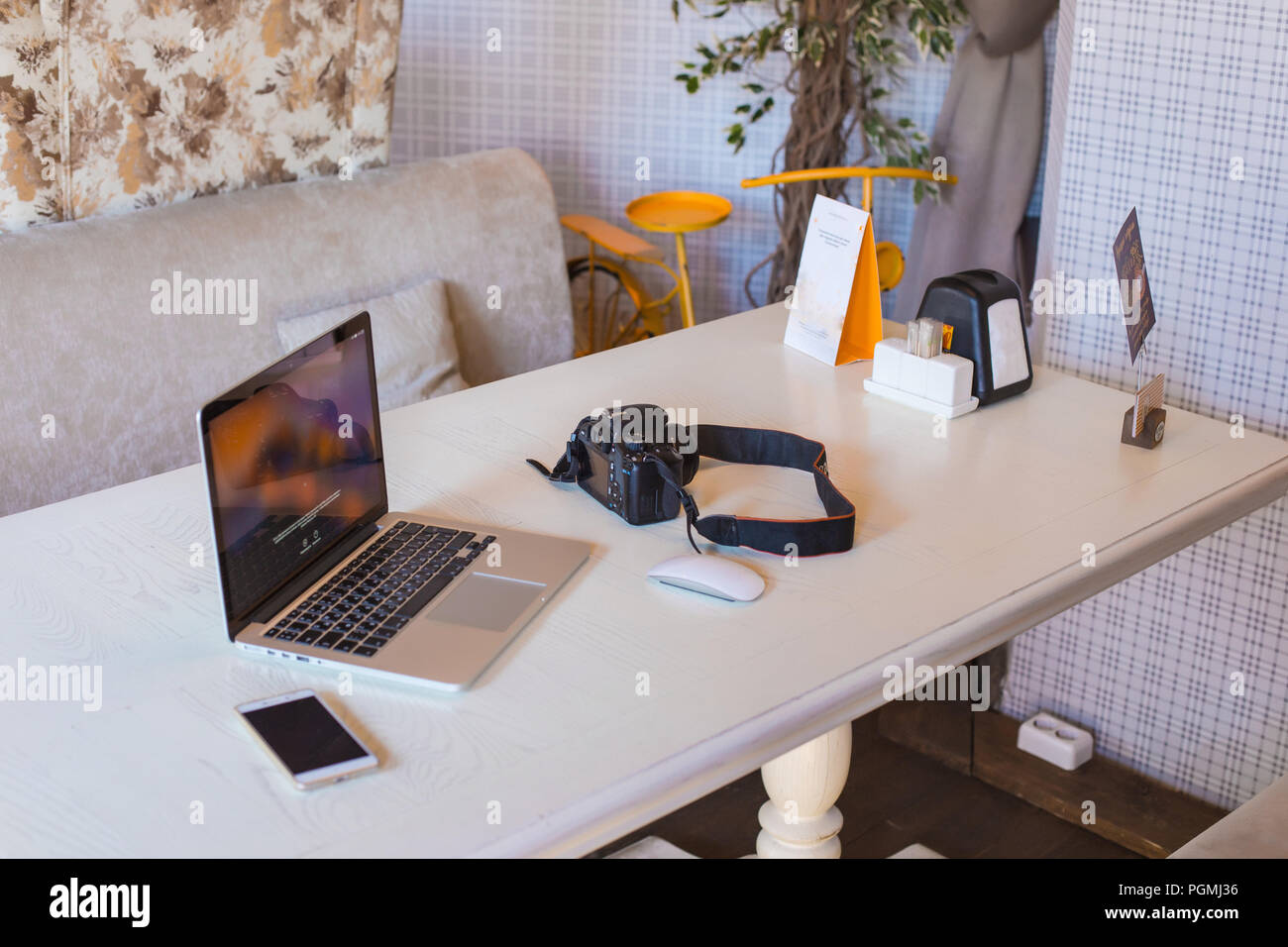 Laptop, phone, camera on a modern desktop. A view on the background of ...