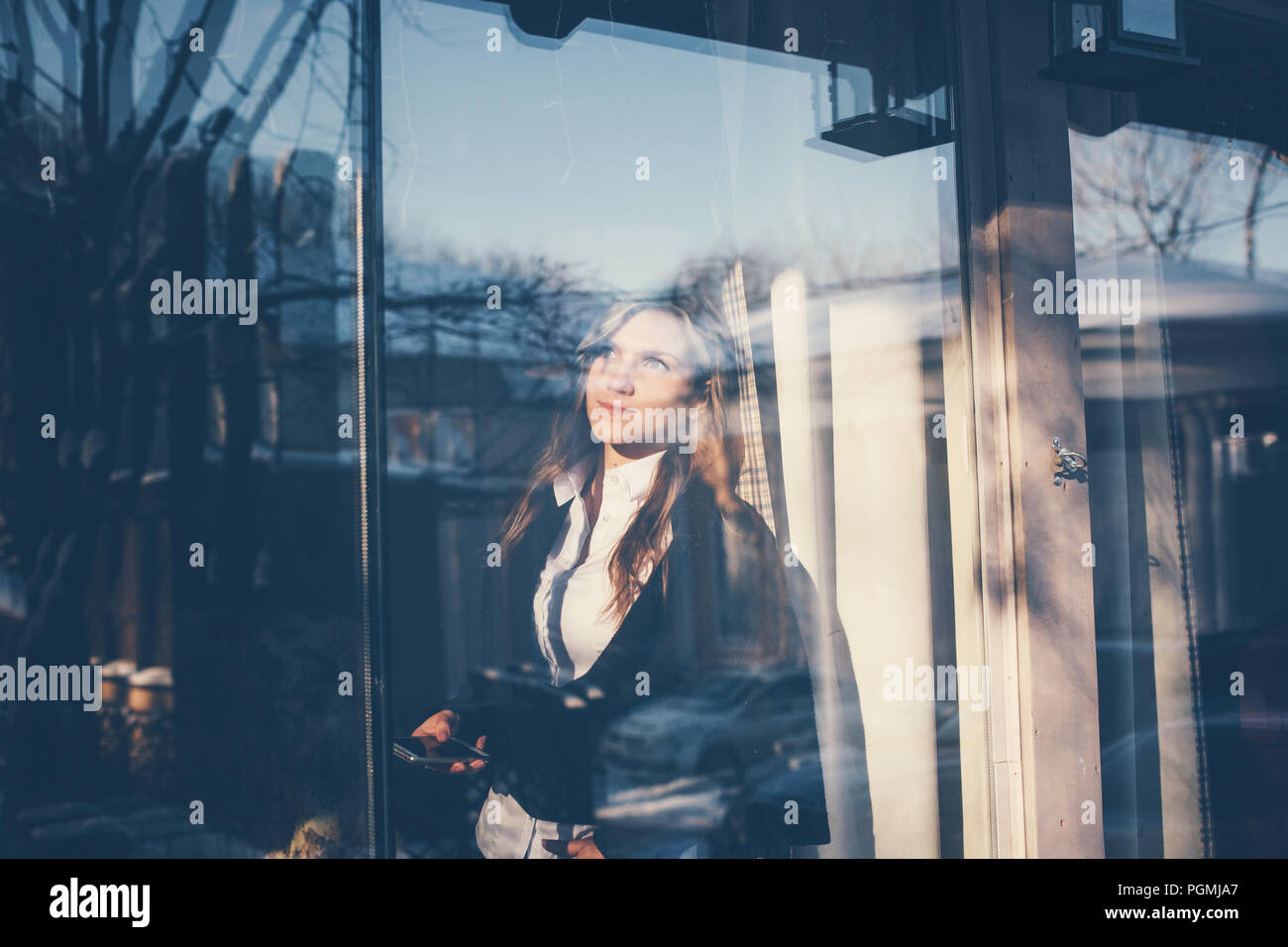 The woman looked out the window of the cafe. A young girl looks through ...