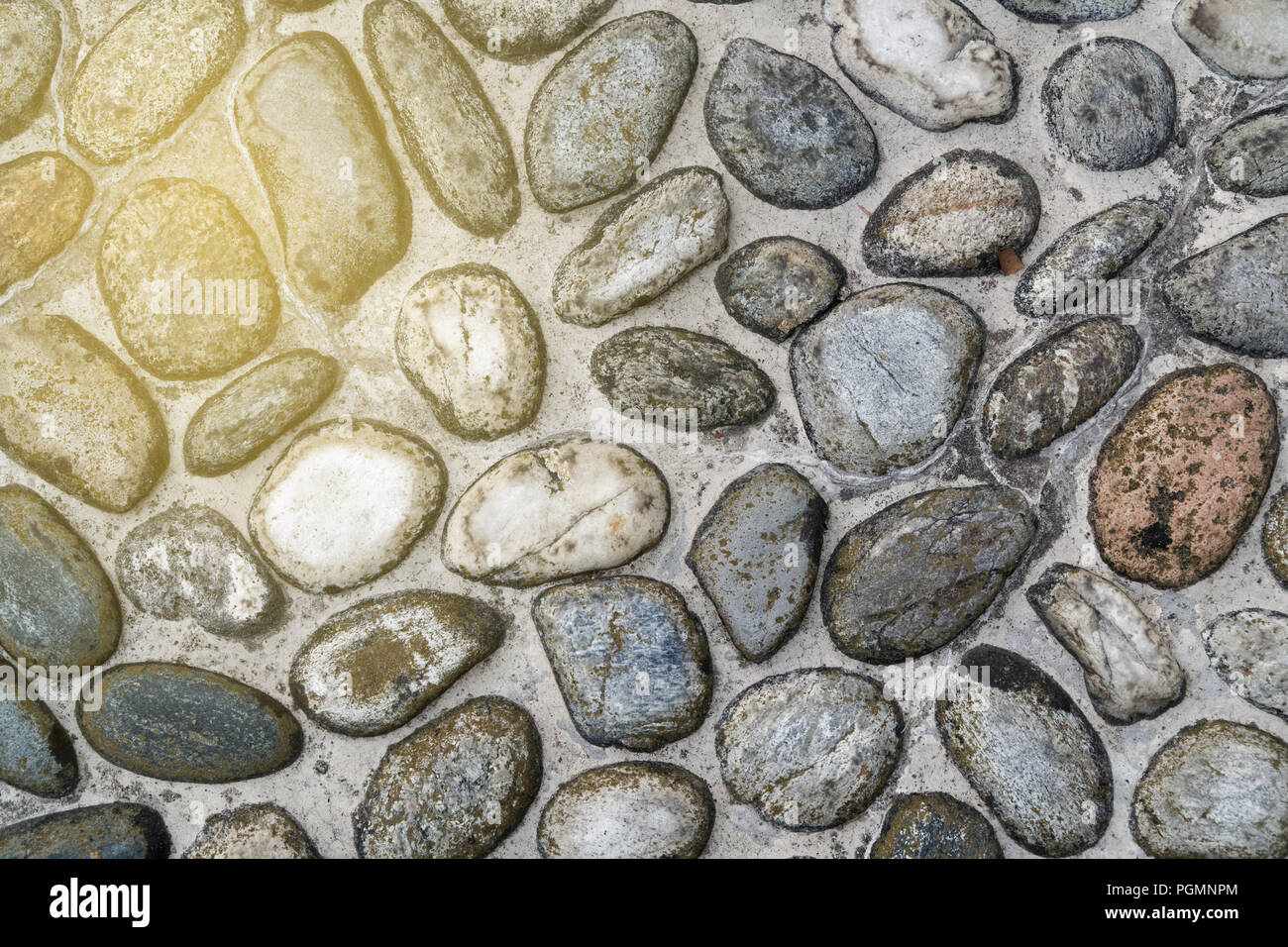 Pebbles ancient floor background in sunbeam light ,closeup big stones ...