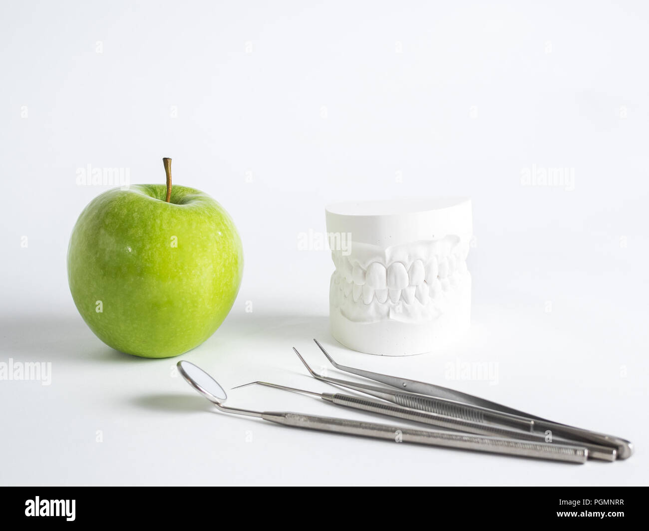 Green apple and dental tools isolated on white Stock Photo - Alamy